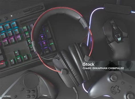 게이머 작업 공간 개념 상단 보기 게이밍 기어 마우스 키보드 조이스틱 헤드셋 모바일 조이스틱 귀헤드폰과 마우스 패드에 검은 테이블 배경 Brand Name Video