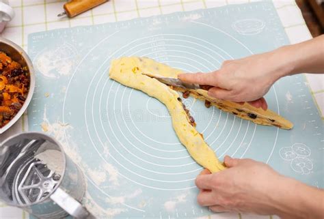 Hands Slice Fruit Filled Sweet Bread Dough On A Light Blue Pastry Mat