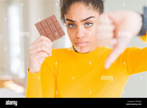 Young African American Girl Eating Dark Chocolate Bar As A Sweet Snack