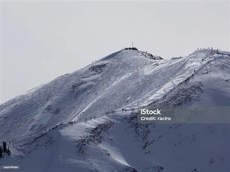 수십 명의 스키어와 스노우 보더가 12392 피트 하이랜드 피크로 하이킹하여 볼을 스키를 타는 망원보기 0명에 대한 스톡 사진