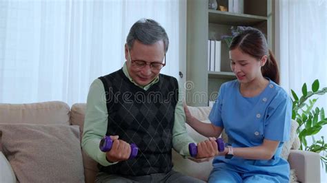 Asian Caregiver Woman Or Nurse Training Senior Woman Lifting Dumbbell