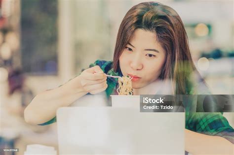 현대 사무실의 유리 옆에 책상에 러시 아워에서 행복 작업으로 국수를 먹는 캐주얼 정장에 아시아 사업가의 초상화 비즈니스 작동
