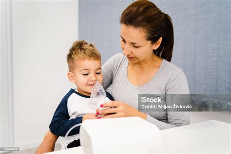 여자 어머니는 증기 증기 흡입기 분무기 마스크 흡입을 사용하여 그녀의 작은 아들 소년 아이를 집 이나 병원 의료 절차 약치료