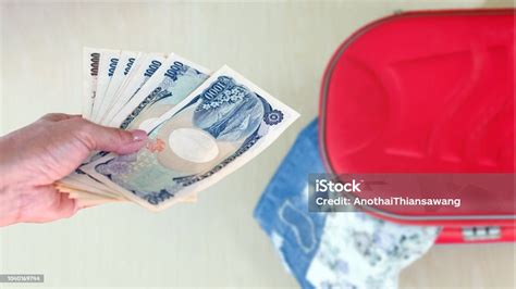 Hand Woman With Japanese Currency Yen Bank Notes On Blurred Background