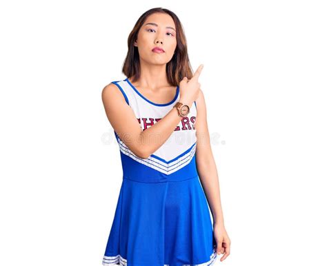 Young Beautiful Chinese Girl Wearing Cheerleader Uniform Pointing With