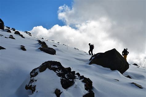 雪に覆われた山に登るカップルの写真 Unsplashの雪山の無料画像