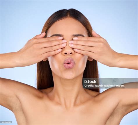 뷰티 스킨케어 여성은 파란색 스튜디오 배경에 눈 피부과 트리트먼트를 가리고 있습니다 여성 화장품 및 숙녀 얼굴에 손을 대고 아침 루틴과 놀라움과 부드러운 피부로 손질합니다