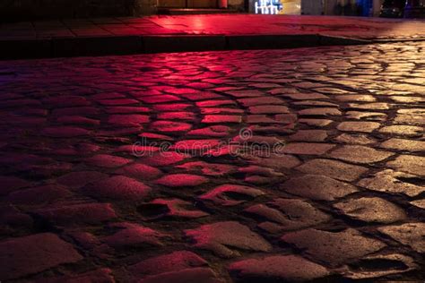 Illuminated By Red Light Cobblestone Street At Night Stock Image