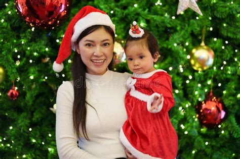Happy Mother With Daughter In Santa Dress And The Christmas Tree Happy