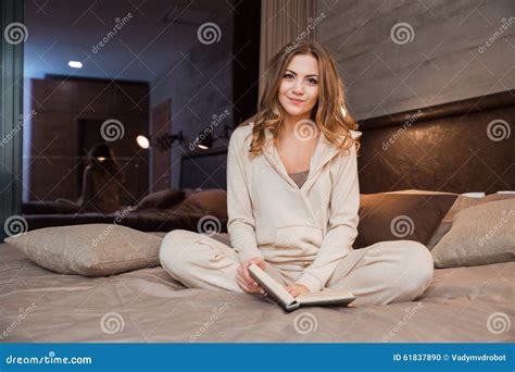 Ragazza Riccia Piacevole Che Si Siede Sul Letto E Sulla Lettura Fotografia Stock Immagine Di