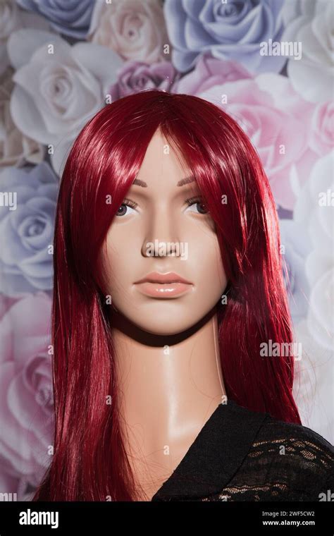 Plastic Woman Mannequin With Long Straigt Red Hair Posing In Front Of A