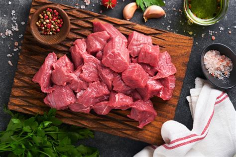 생 다진 쇠고기 고기 생 유기농 고기 쇠고기 또는 양고기 향신료 어두운 회색 콘크리트 배경에 오래된 나무 보드에 허브 굴라쉬