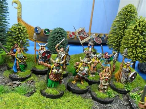 A Group Of Figurines That Are Standing In The Grass With Trees Behind Them