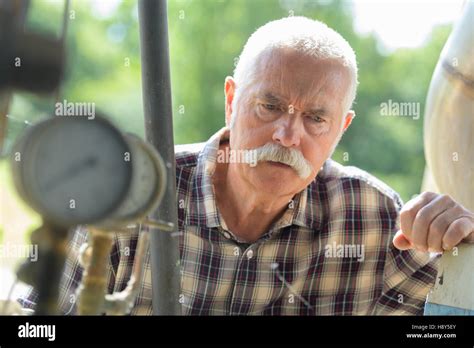 Old Man Outdoors Checking Machine Stock Photo Alamy