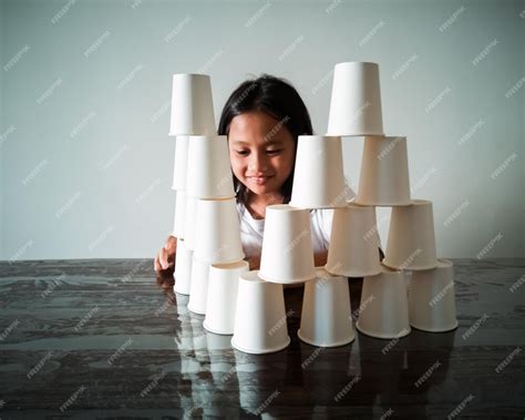 Premium Photo Smiling Girl Stacking Glasses
