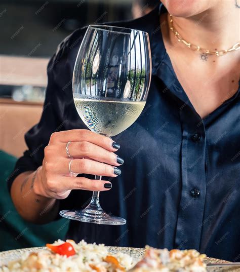 Premium Photo A Woman Holding A Wine Glass With A Wine Glass In Front