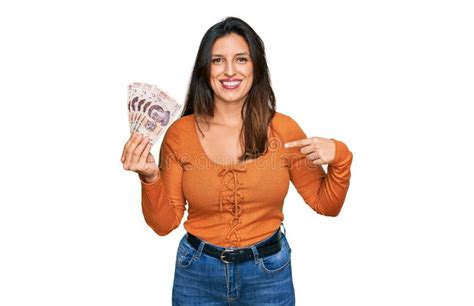 Beautiful Hispanic Woman Holding Mexican Pesos Pointing Finger To One