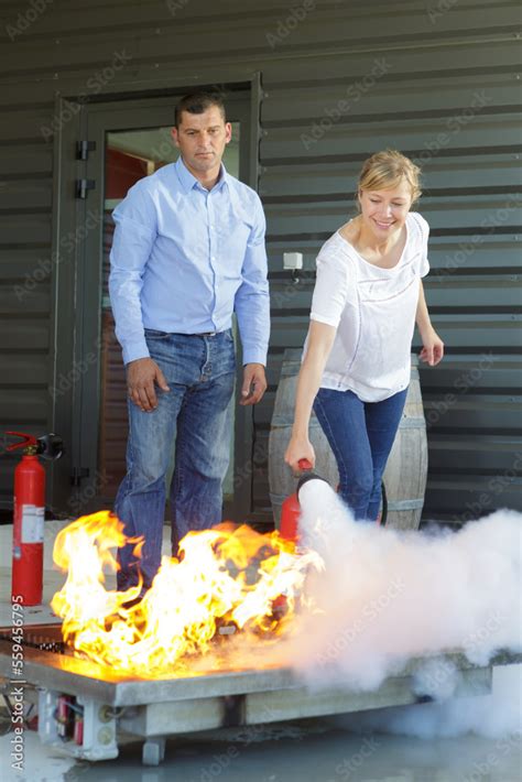 Woman Demonstrating How To Use A Fire Extinguisher Stock Photo Adobe Stock