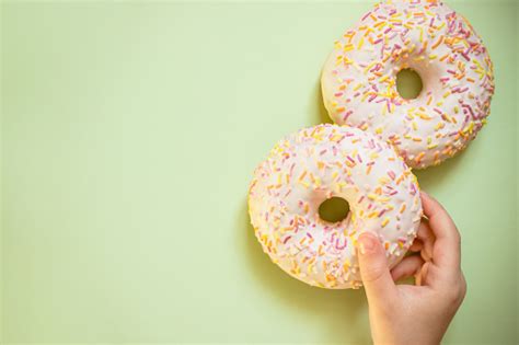 달콤한 맛 있는 간식 아이 손 녹색 배경 평면도에 유약된 도넛을 잡고 복사 공간 건강에 해로운 음식을 Conceptclassic