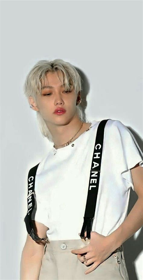 A Woman With Blonde Hair Wearing A White T Shirt And Grey Pants