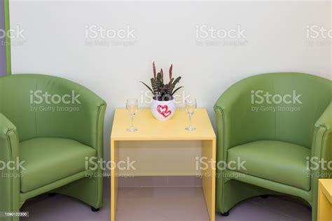 두 개의 녹색 가죽 안락의 자 그리고 테이블에 중간에 두 개의 와인 유리와 꽃 냄비와 노란색 커피 테이블 0명에 대한 스톡 사진 및 기타 이미지 Istock