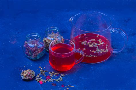 유리 컵과 주전자에 적차 와 어두운 배경에 마른 차 잎과 꽃잎 항아리 허브 비타민 감기와 독감에 대한 해독 차 닫기 텍스트에