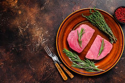 접시에 로즈마리와 백리향을 곁들인 생 참치 필레 어두운 배경 맨 위 보기입니다 복사 공간 0명에 대한 스톡 사진 및 기타 이미지