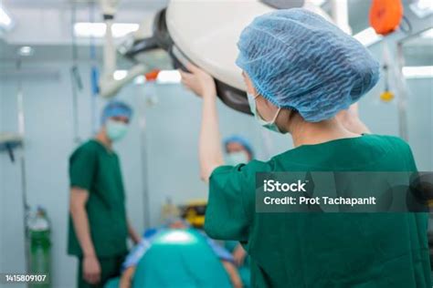 병원의 수술실에 서있는 의료용 마스크를 쓴 아시아 외과 의사의 뒤에 전문 외과 의사 팀 의료응급의료 서비스 개념 간호사에 대한
