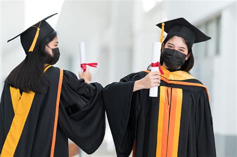 여성 대학생 대학 졸업생 검은 모자를 착용 노란색 술과 전염병 동안 마스크를 착용 20 24세에 대한 스톡 사진 및 기타 이미지 20 24세 2명 검은색 Istock