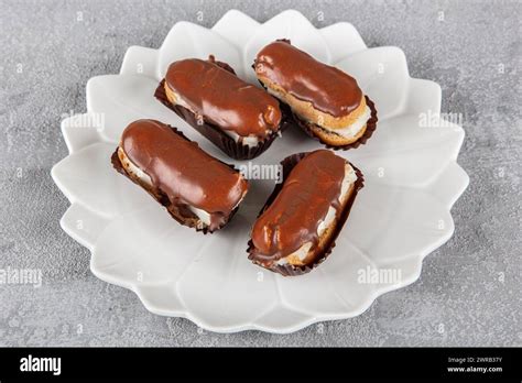 Eclairs With Chocolate Topping On Serving Plate Traditional French