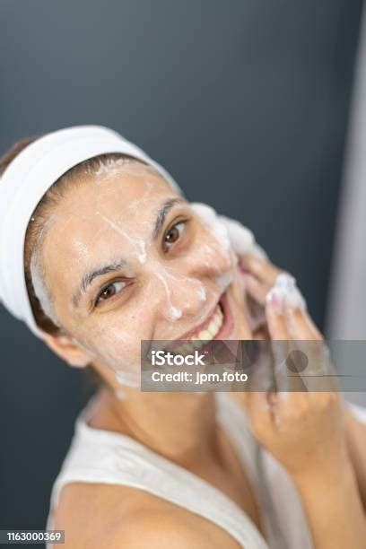 모공을 정화하기 위해 흰색 거품으로 얼굴을 마사지하는 아름답고 편안한 여성의 탑 뷰 건강관리와 의술에 대한 스톡 사진 및 기타 이미지 건강관리와 의술 관광 리조트