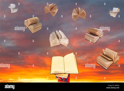 Open Book Above Of Stack Of Books And Sunset Sky With Flying Books