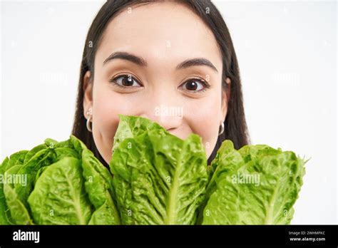 Close Up Portrait Of Happy Korean Woman Shows Her Face With Lettuce