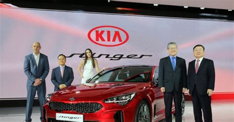 스팅어와 함께 포즈 취하는 기아차 관계자들