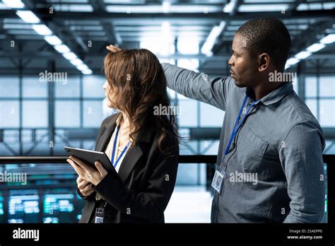 Coworkers Holding Tablet Looking Around Data Center Managing Server Virtualization Server