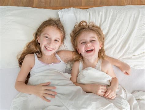 Zwei Kleine Schwestern Die Im Bett Umarmen Stockfoto Bild Von Kinder