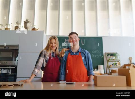 Young Down Syndrome Waiter Working With Colleague In Take Away