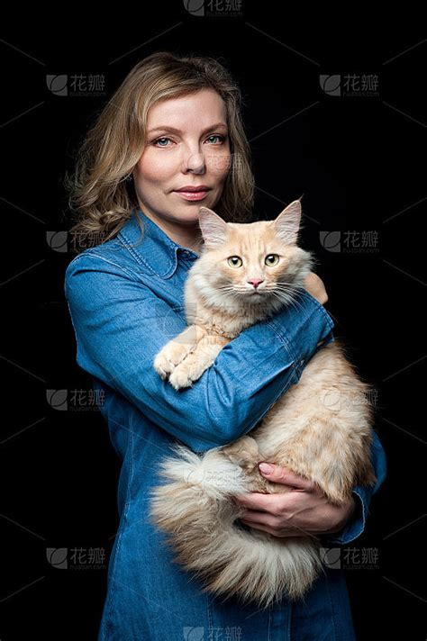 美丽的女主人与她的猫在一个黑色的背景