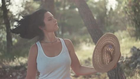 Girl Takes Off Her Hat And Straightens Her Hair In The Park Stock Footage