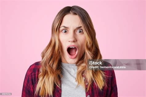 충격된 무능된 여성 학생 열고 입은 널리 체크 무늬 셔츠 핑크 배경 위에 절연 착용 내일 마지막 시험 인지 놀라게 되 고 인간의 부정적인 감정 개념 걱정하는에 대한 스톡