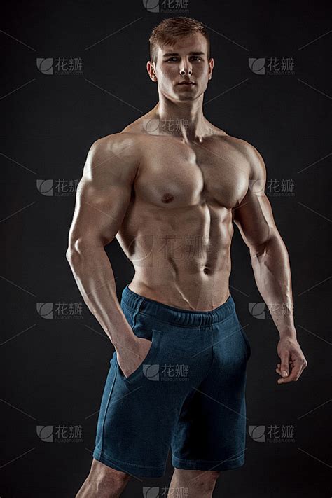 肌肉健美的家伙在黑色背景上摆姿势