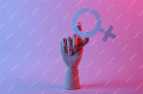 핑크 블루 그라데이션 네온 불빛에 금성 페미니즘 기호를 들고 나무 손 프리미엄 사진