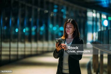 검은 코트를 입은 아름다운 여성이 밤에 네온 불빛으로 현대 도시 거리를 걷고 있는 모습 35 39세에 대한 스톡 사진 및 기타