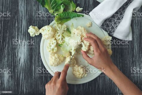 나무 테이블에 신선한 콜리플라워를 자르는 여성스러운 손 여름 음식 개념 위쪽 보기 0명에 대한 스톡 사진 및 기타 이미지 0