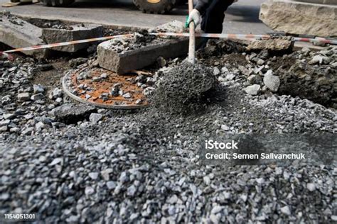 교통 도시 거리의 높은 보기 자갈 및 지구 발동기 황소도 저 양동이와 함께 보도 콘크리트 시멘트의 깨진 덩어리의 수리 오렌지 콘을 가진 측량 장비 0명에 대한 스톡 사진 및