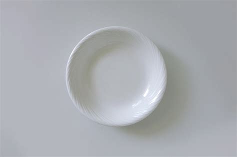 흰색 배경에 고립 된 흰색 둥근 세라믹 플레이트 냄비의 좋은 디자인 식품 장식 및 포장 디자인을 위한 상단에서 단 하나의 도자기
