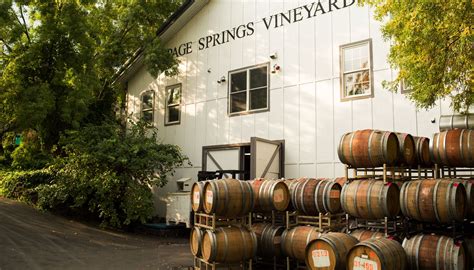 Several Wine Barrels Are Stacked Up In Front Of A Winery