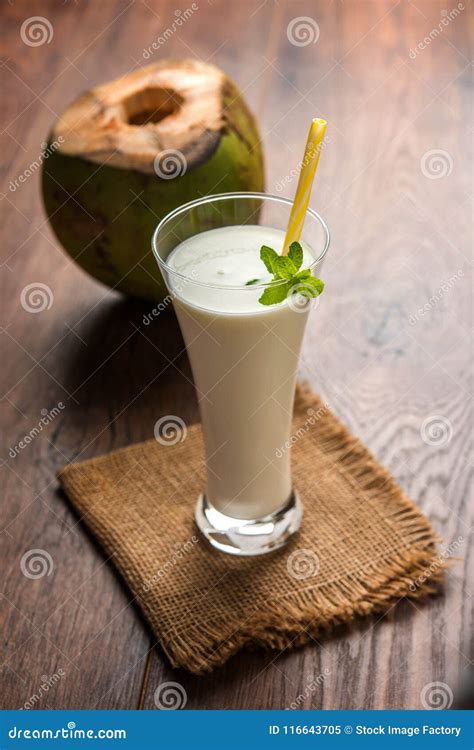 Coconut Flavoured Plain White Lassi Or Milk Shake Garnished With A Coconut And Mint Leaves