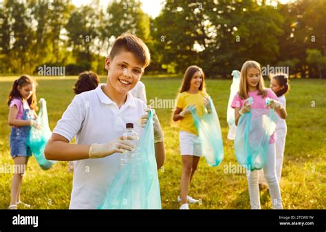 Portrait Of Preteen Boy Collecting Plastic Trash During Summer Cleanup