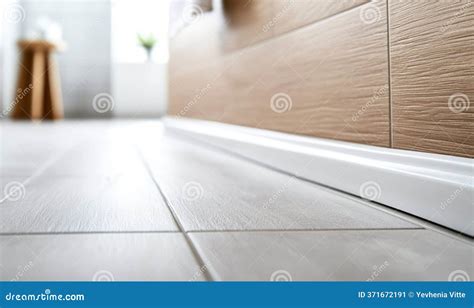 White Baseboard Trim Meets Light Brown Wooden Floor Interior Detail In